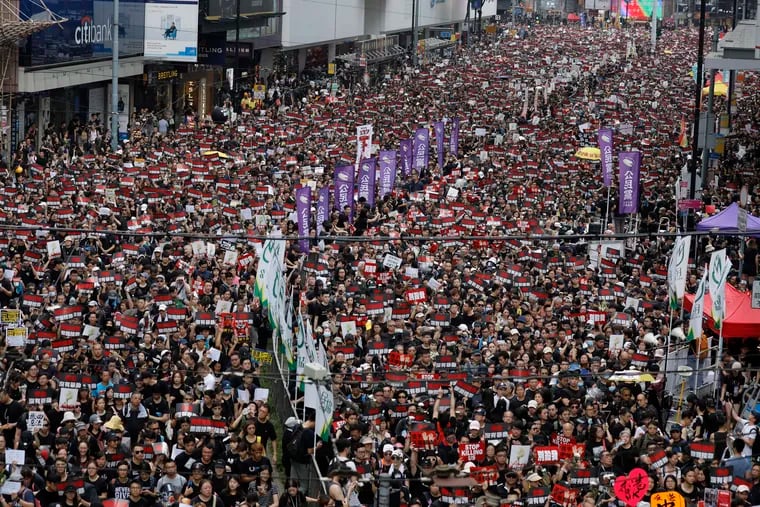 Huge crowds march in Hong Kong, piling pressure on leader